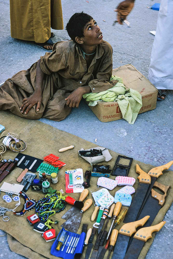 Boy with Merchandise Looking Up, Abu Dhabi – Jay Maisel